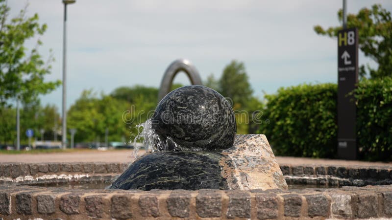 A Water Fountain with a Spinning Ball. a Statue of a Ball in a Fountain ...