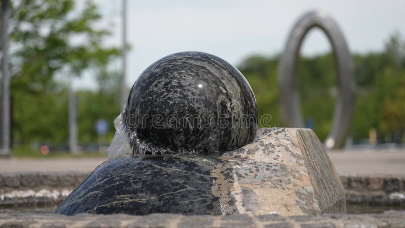 A Water Fountain with a Spinning Ball. a Statue of a Ball in a Fountain ...