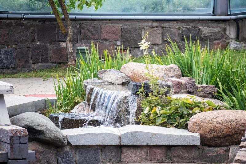 .a Fountain in the Middle of a Stone Garden with Flowers Stock Image ...