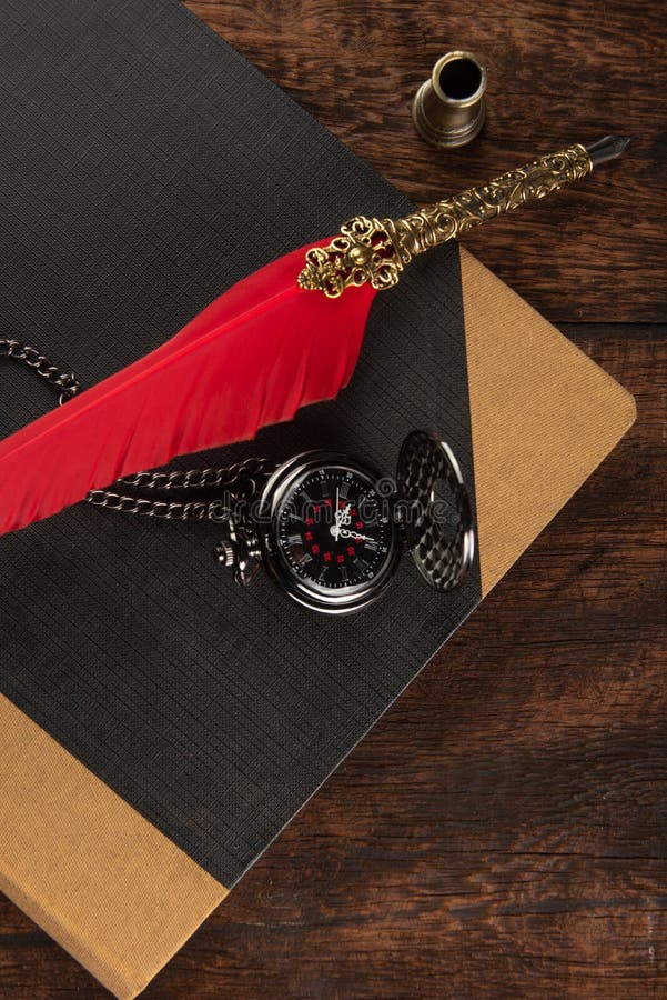 Fountain Pen with Red Feather on a Notebook and an Old Watch, Top View ...