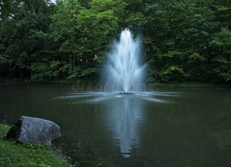 Fountain on calm pond stock photo. Image of flower, park - 4557400