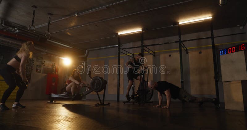Four Athletic People Doing Different Intense Exercises during Strength ...