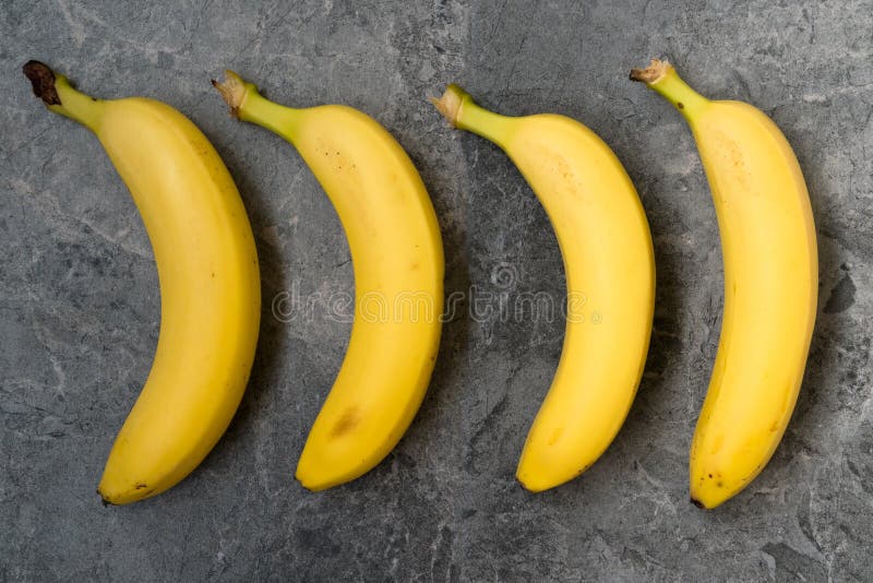 Four Bananas on the Dark Stone Background Stock Image - Image of fruit ...