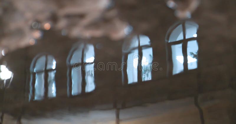 Snow is Melting on City Streets. Four Blue Windows are Reflected in a ...