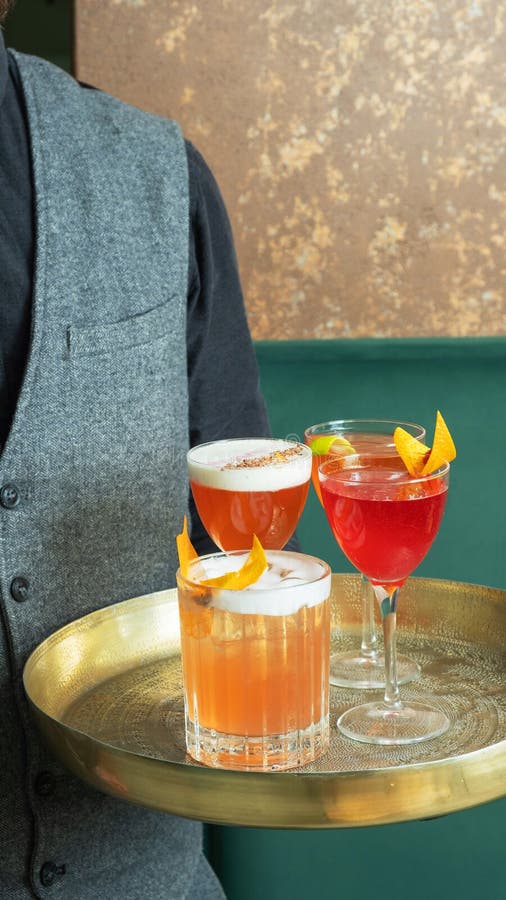 Four Bright Alcoholic Cocktails on Tray in Glasses in the Hands of ...