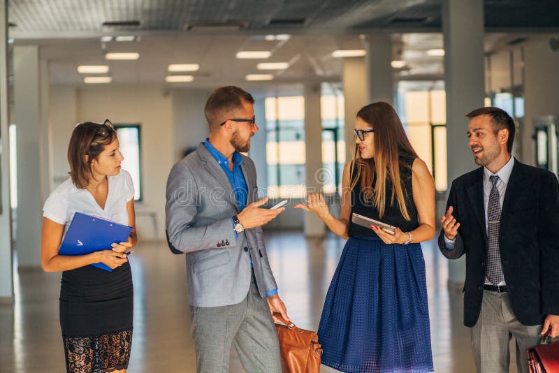 Four Business People Talking in Office Lobby Stock Photo - Image of ...