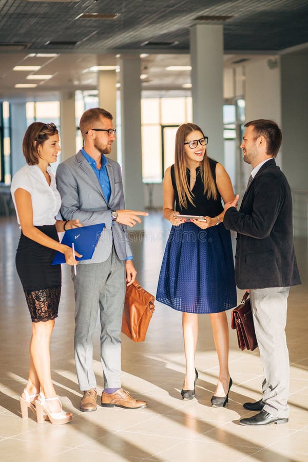Four Business People Talking in Office Lobby Stock Photo - Image of ...