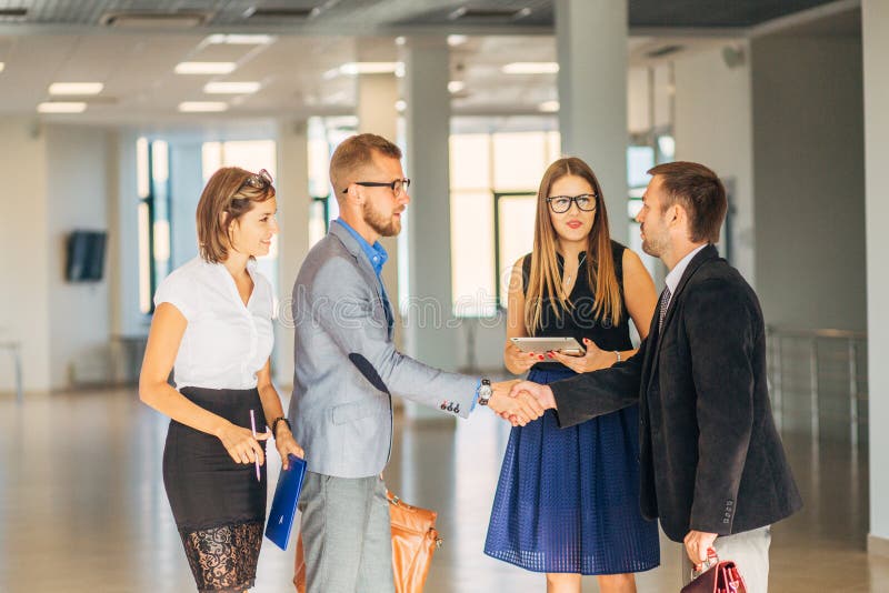 Four Business People Talking and Walking in Office Lobby Stock Image ...