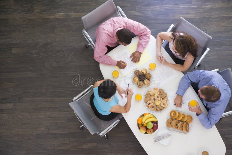 Four Businesspeople Eating at Boardroom Table Stock Image - Image of ...