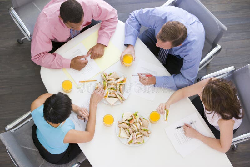 Four Businesspeople Eating at Boardroom Table Stock Photo - Image of ...