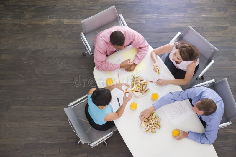 Four Businesspeople Eating at Boardroom Table Stock Image - Image of ...