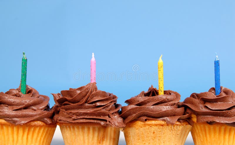 Four Chocolate Frosted Cupcakes in a Row with Candles Stock Image ...