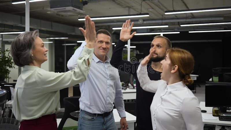 Four Co-workers Give a High Five in the Office. Slow Motion. Stock ...