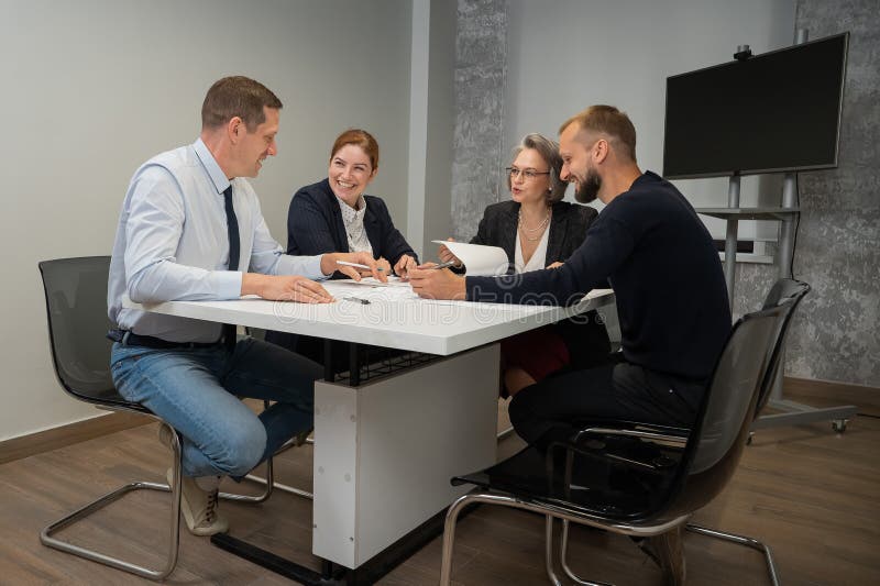 Four Colleagues are Discussing Blueprints in a Conference Room in an ...