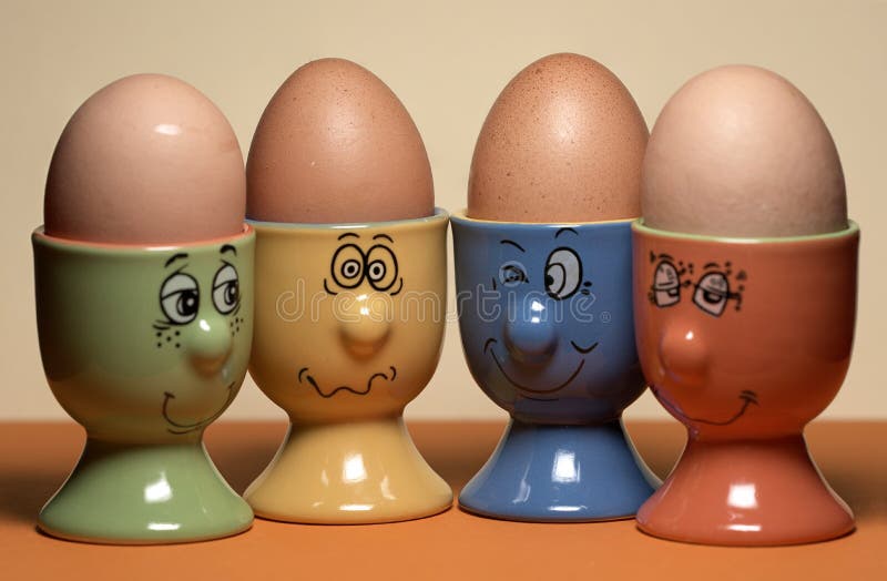 Four Comedy Egg Cups Filled with Brown Eggs Stock Photo - Image of ...