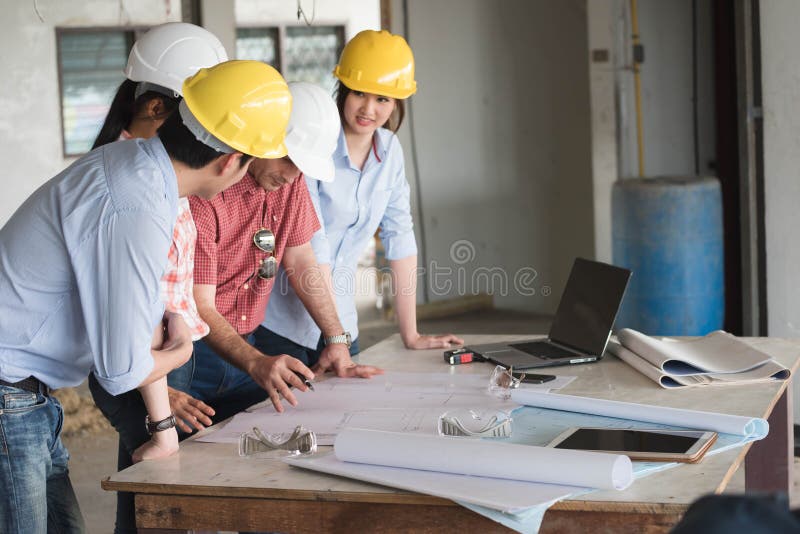 Four Construction Engineer Working on Blue Print in Side Building Plan ...