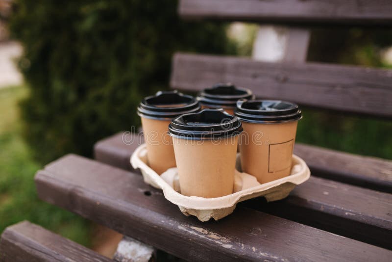 Four Cup with Coffe on Bench Outdoors. Take-out Concept Stock Photo ...