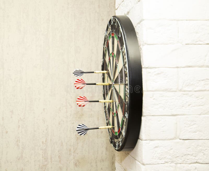 Four Darts Stuck in a Dart Board on a Brick Column. Close-up Stock ...