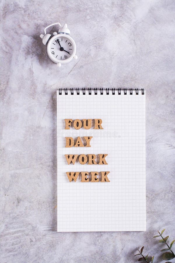 Four Day Work Week Concept Wooden Letters on Notebook and Alarm Clock ...