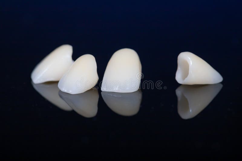 Four Dental Crowns Zirconia on a Mirror Table, Black Background. Crowns ...