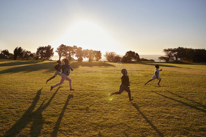 Elementary School Kids Playing Football in a Field, Back View Stock ...