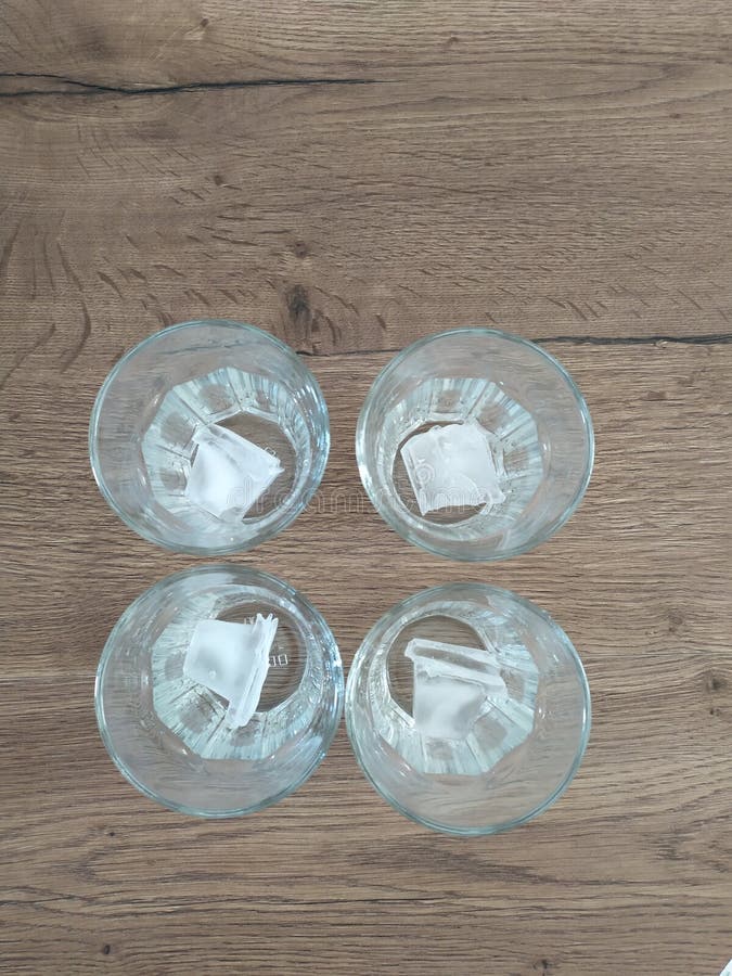 Four Empty Glasses of Ice on a Wooden Table Stock Image - Image of ...