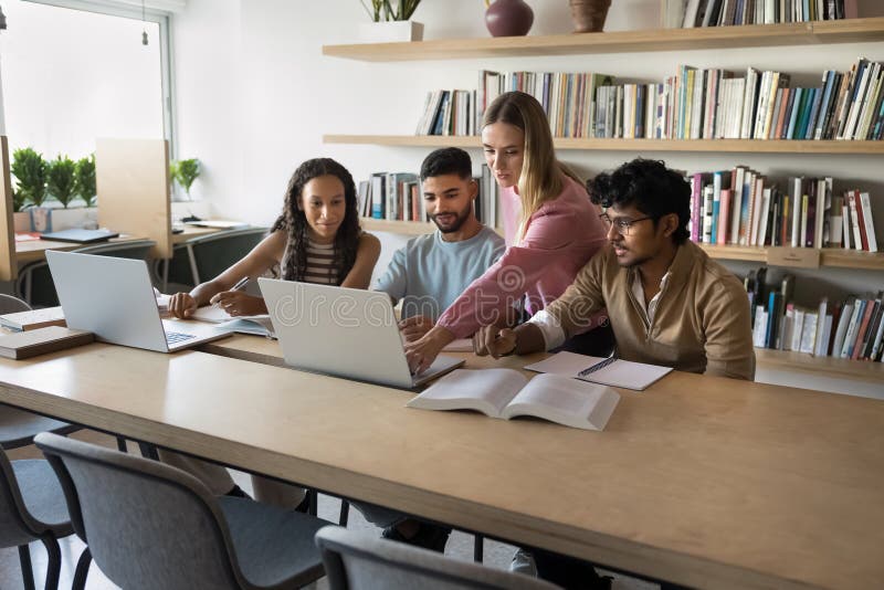 Four Focused Multiethnic Students Do Assignment in Library Stock Photo ...
