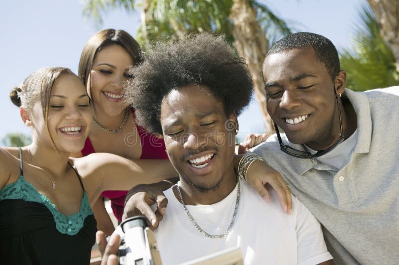 Four Friends in Back Yard Looking at Video Camera Screen Front View ...