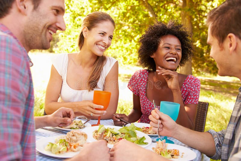 Four Friends Eating Together Outdoors Stock Photo - Image of happy ...
