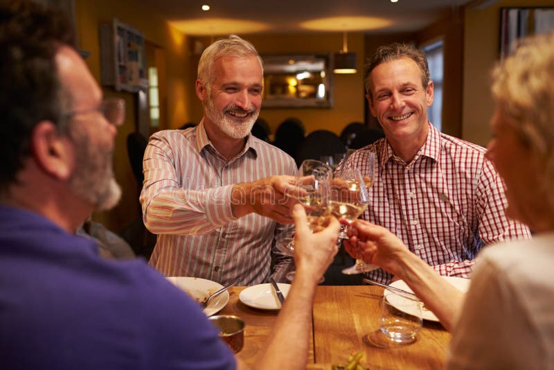 Four Friends Enjoying Dinner At A Restaurant Stock Photo - Image of ...