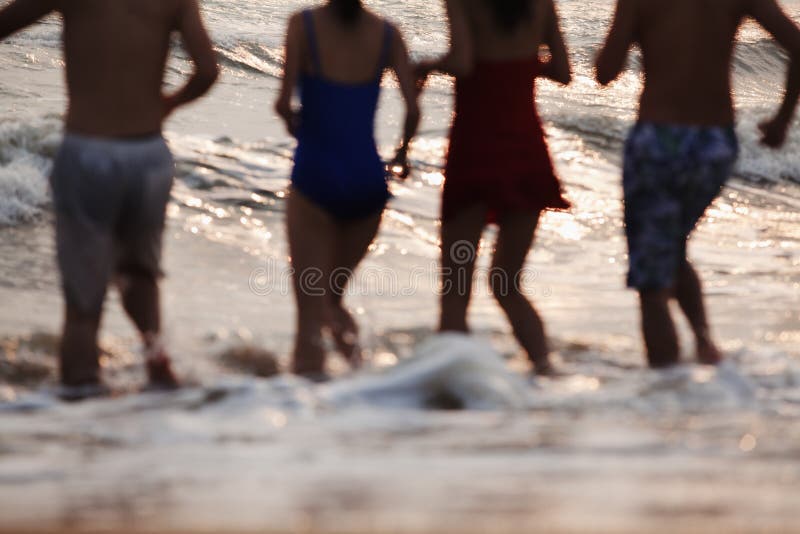 Four Friends Running into the Water on a Sandy Beach, Silhouette Stock ...