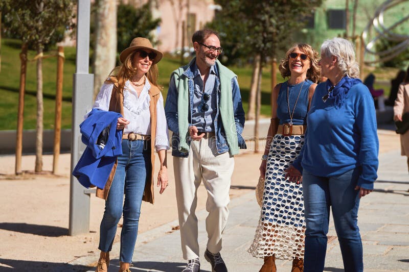 Four Friends in Their 60s Strolling through a City Square. Stock Image ...