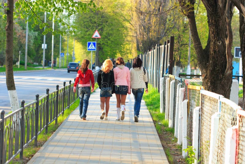 Four Girls Walking Along The Street Stock Photo - Image of leaves ...