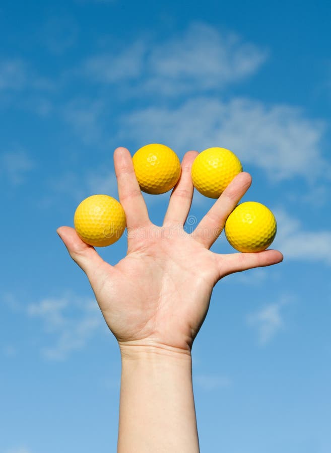 Four golf balls stock photo. Image of hand, green, yellow - 15589094