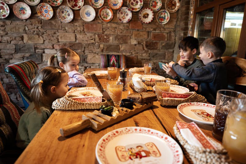 Four Kids Sit in Authentic Ukrainian Restaurant, Looking on Phones ...