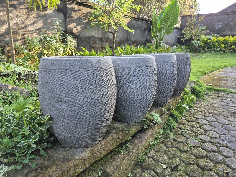 Four Large, Textured Stone Planters Arranged Neatly Along the Edge of a ...