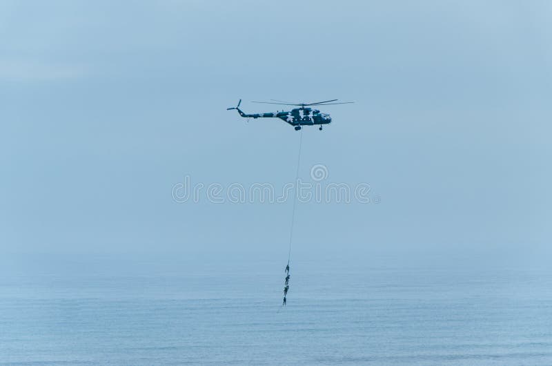 Four Man Climb from Helicopter Down a Rope Stock Image - Image of ...