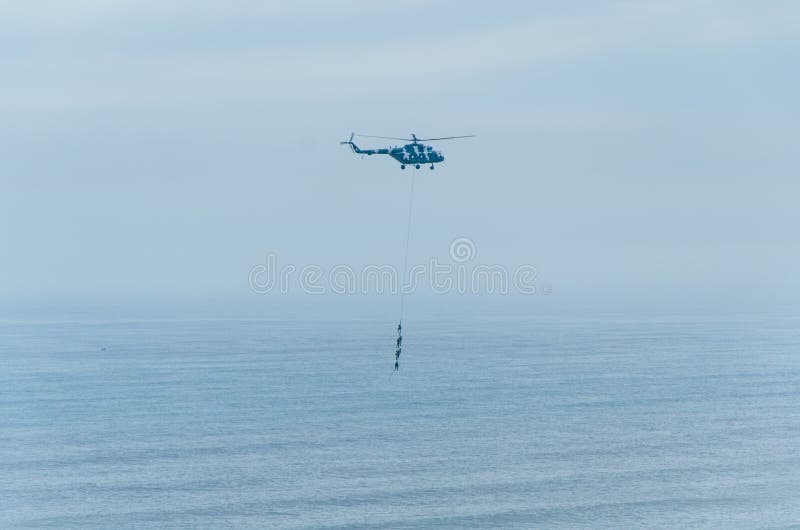 Four Man Climb from Helicopter Down a Rope Stock Photo - Image of ...