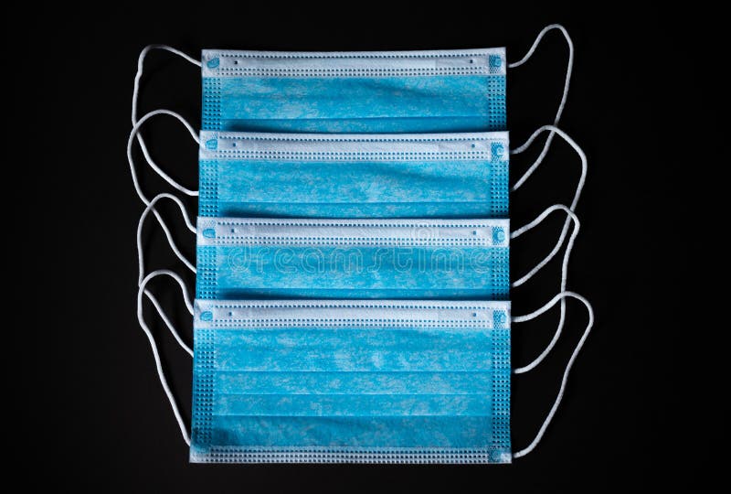 Four Medical Face Masks Lined Up in Black Background Stock Photo ...