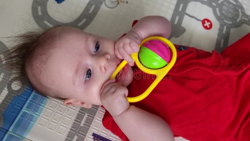 A Four-Month-Old Girl Chews Her Rattle Stock Video - Video of face ...
