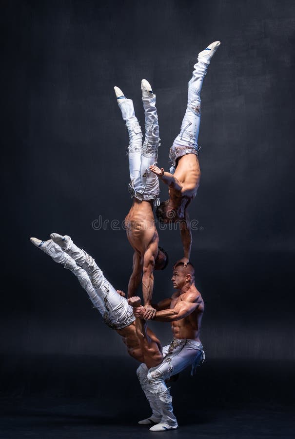 Four Muscular Man Perform Difficult Acrobatic Tricks on Black Studio ...