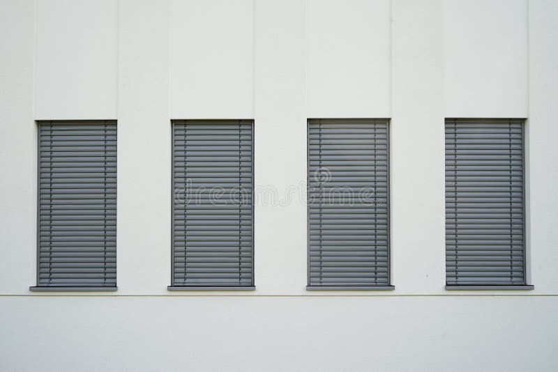 Four Narrow Windows with Closed Gray Role Shutters on the Light Wall ...