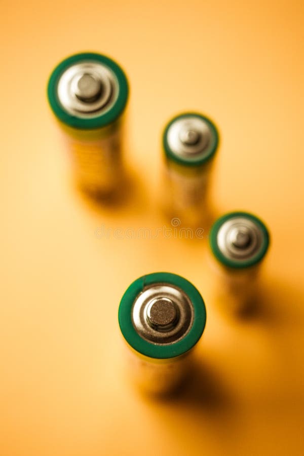 Four New Batteries on the Orange Table, Top View Stock Photo - Image of ...