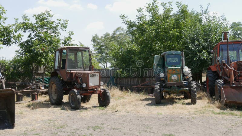 Four Old Vintage Rusty Tractors Stand in a Row on the Farm Stock Video ...