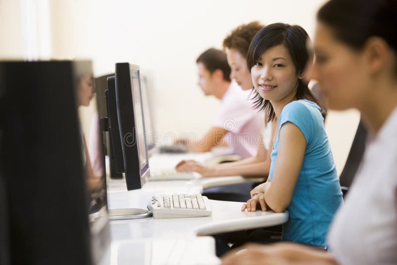 Four People Sitting in Computer Room Smiling Stock Photo - Image of ...