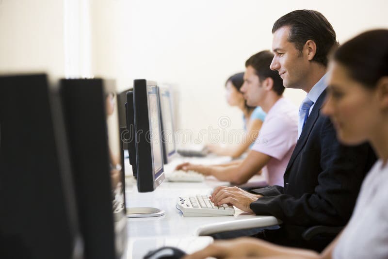 Four People Sitting in Computer Room Typing Stock Photo - Image of ...