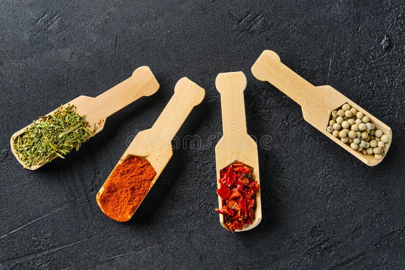 Four Small Wooden Spoons with Spice on Black Concrete Background Stock ...