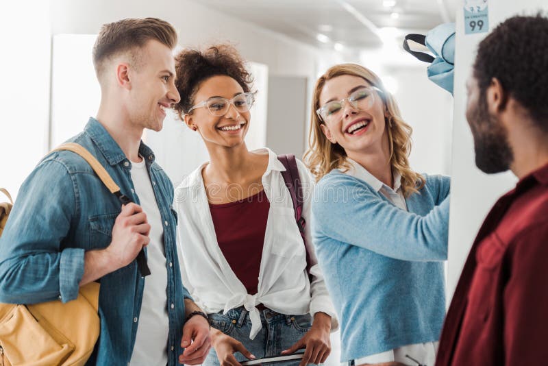 Four Smiling Multiethnic Students Standing in Corridor Stock Photo ...