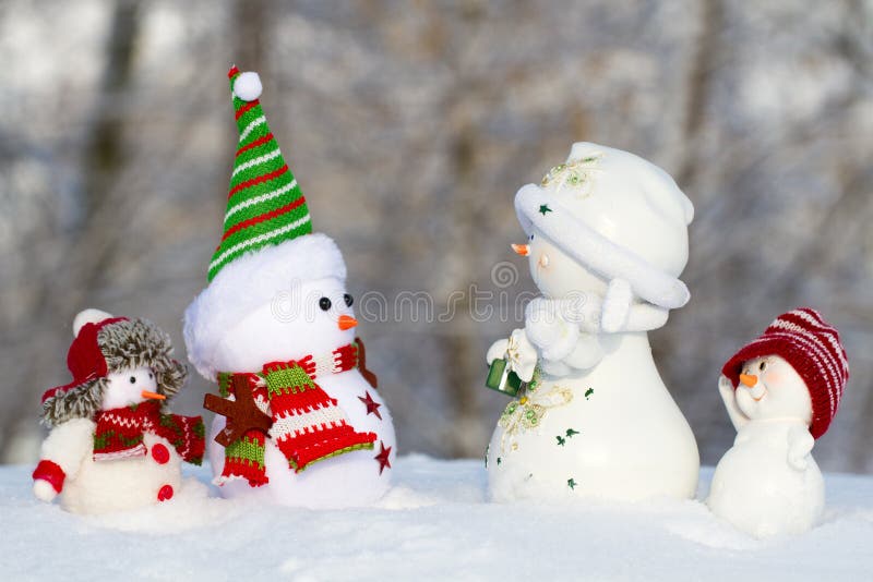 Four Snowman in the Snow Looking at Each Other Stock Photo - Image of ...