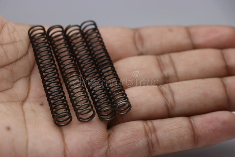 Four Steel Compression Coil Springs Held in Hand. Metal Springs As a ...